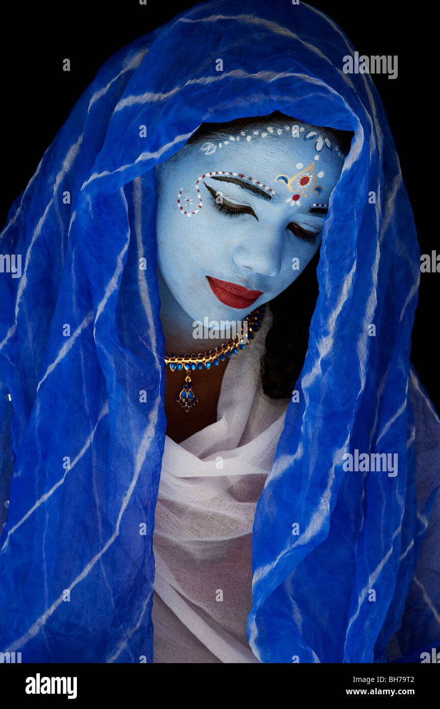 Indian girl, face painted as the Hindu goddess Sita against a black ...