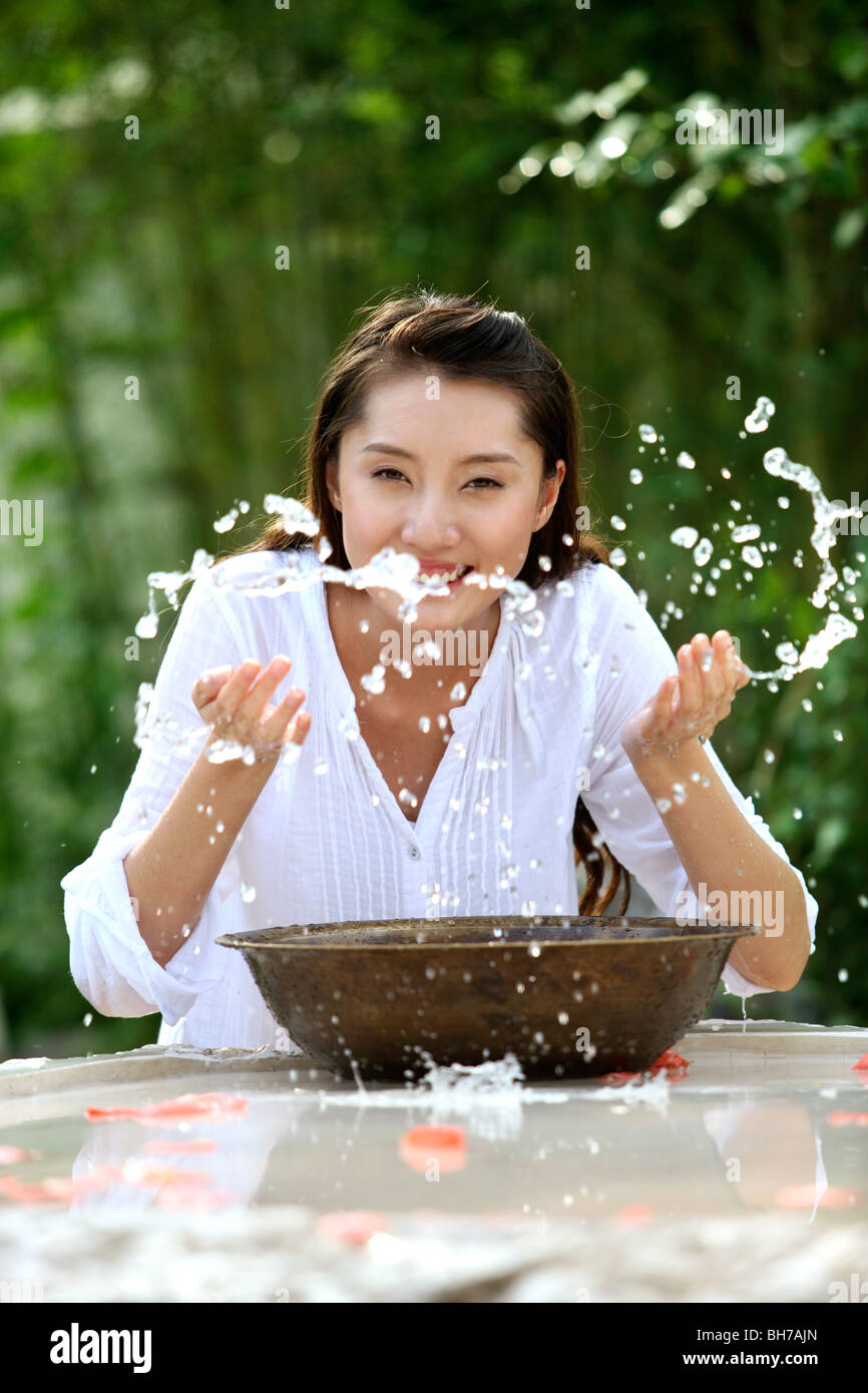 Young woman splashing water on her face Stock Photo - Alamy