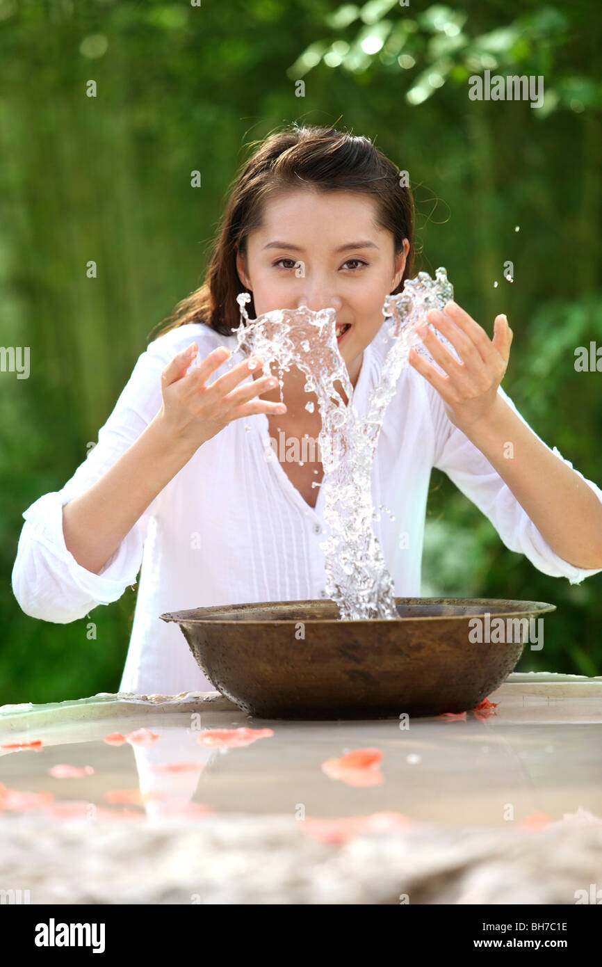 Young woman splashing water on her face Stock Photo - Alamy
