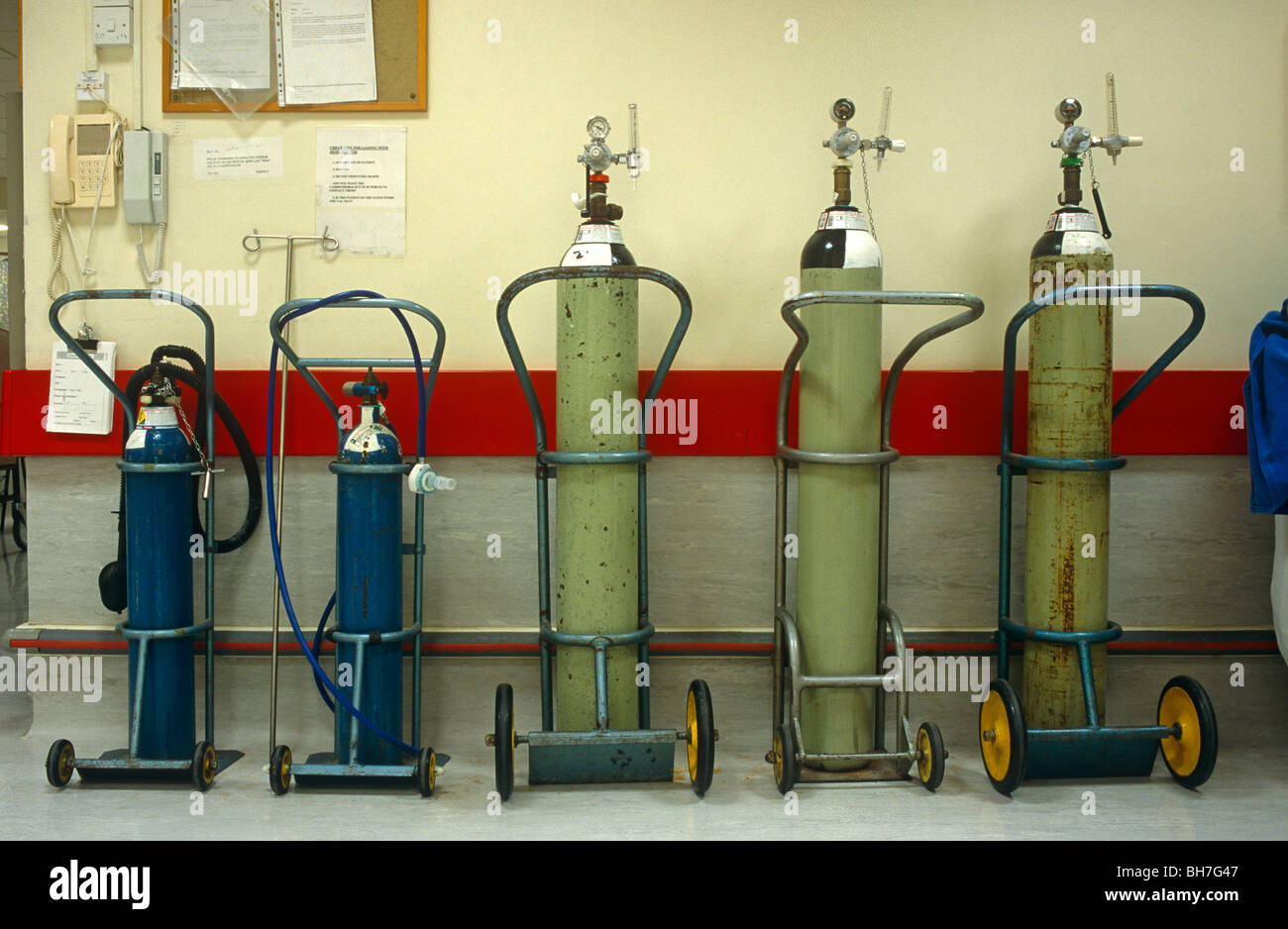 Oxygen cylinders are lined up against a wall in the A&E department of ...