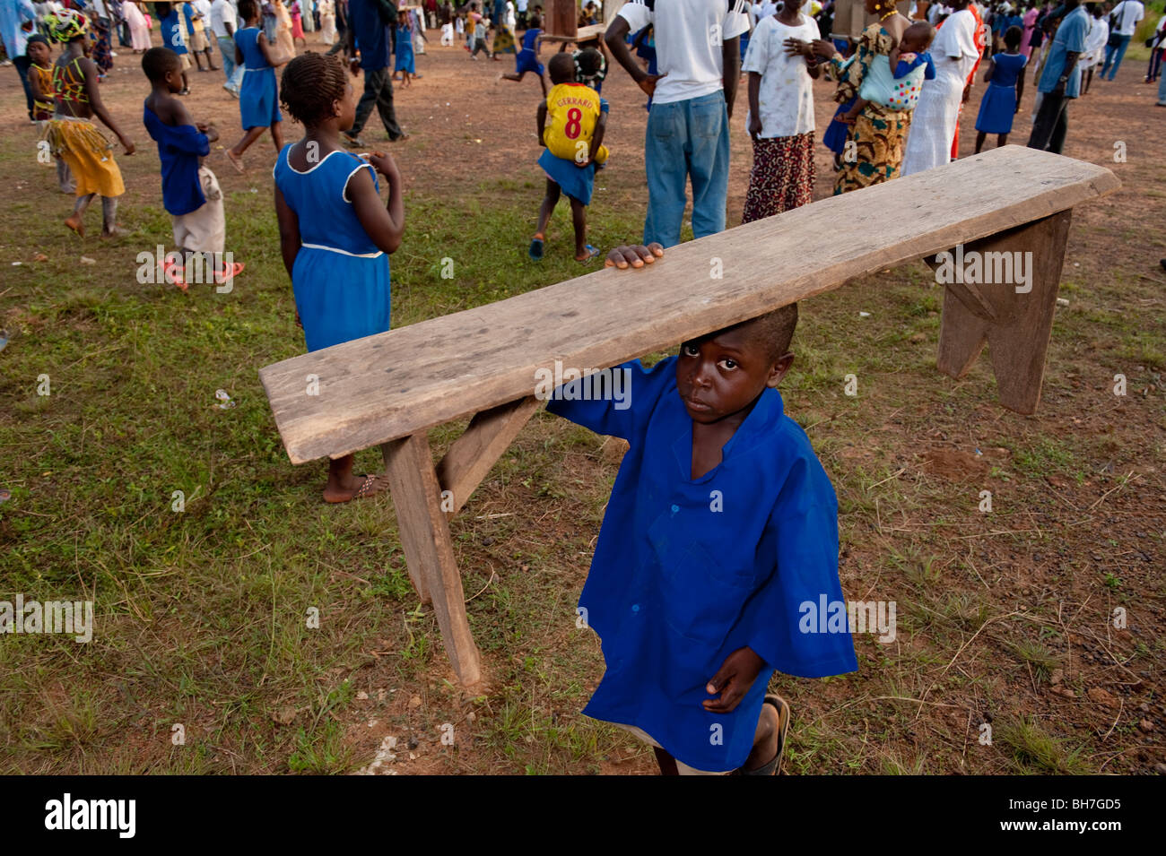 Boy carrying bench at village meeting Ngo town Sierra Leone Stock Photo ...