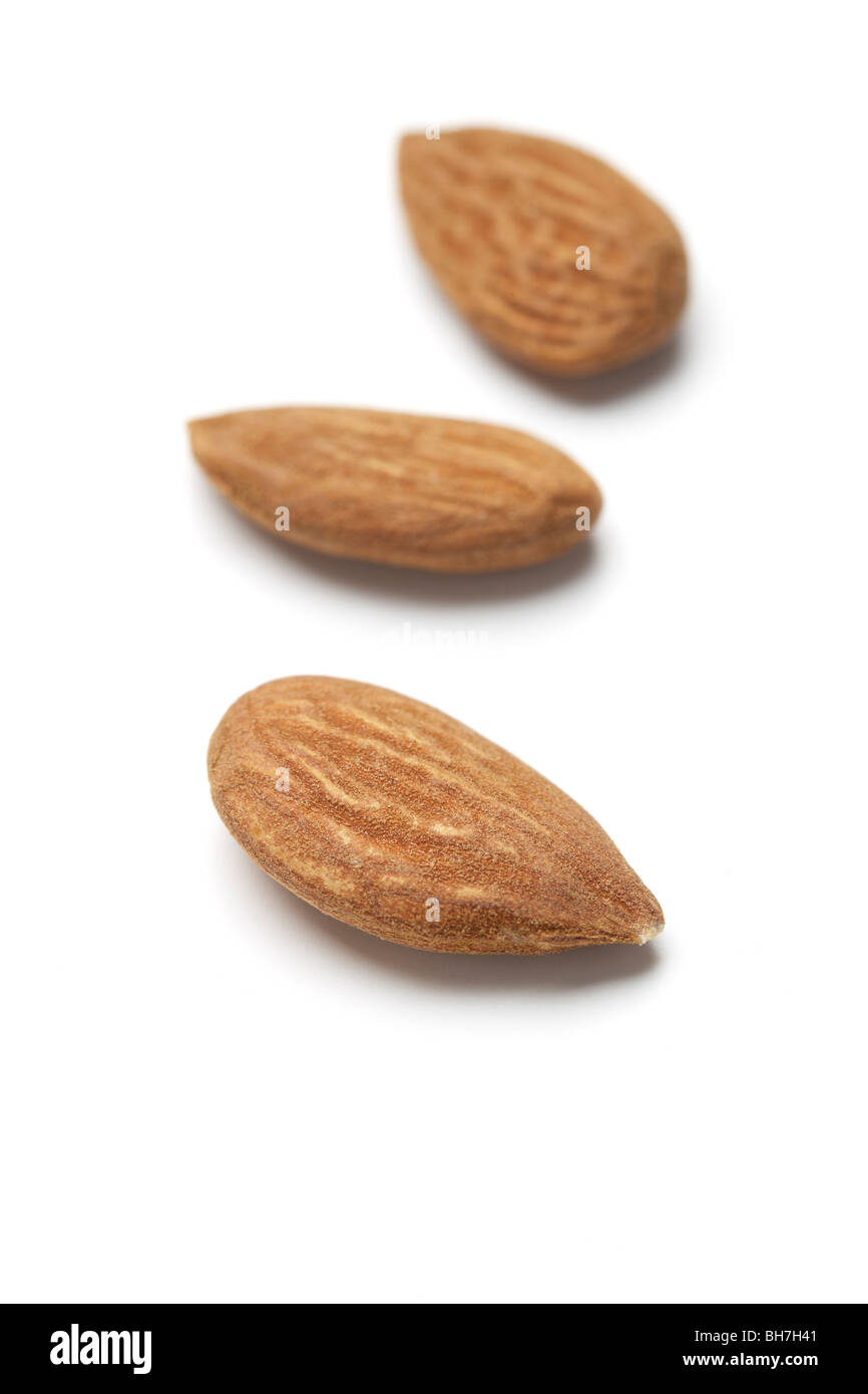 Three almond nut kernals on a white background Stock Photo - Alamy