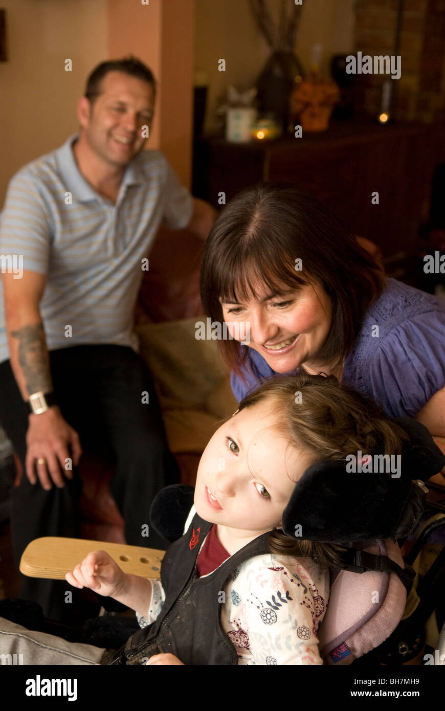 Loving parents with their disabled daughter who suffers from cerebral ...