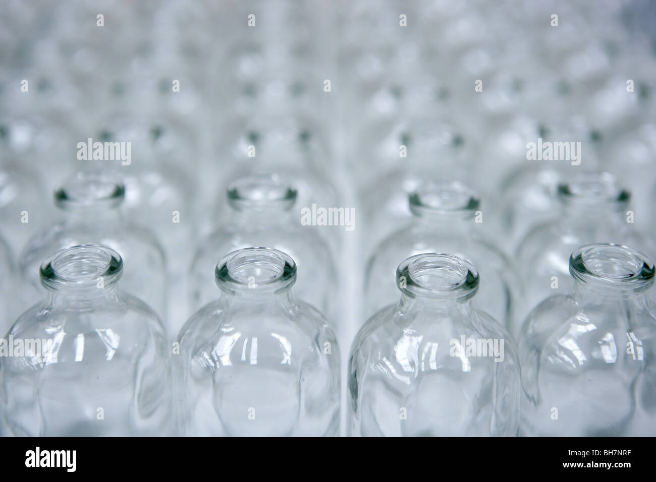 Glass transparent empty bottles in rows, cosmetics assembly line Stock ...