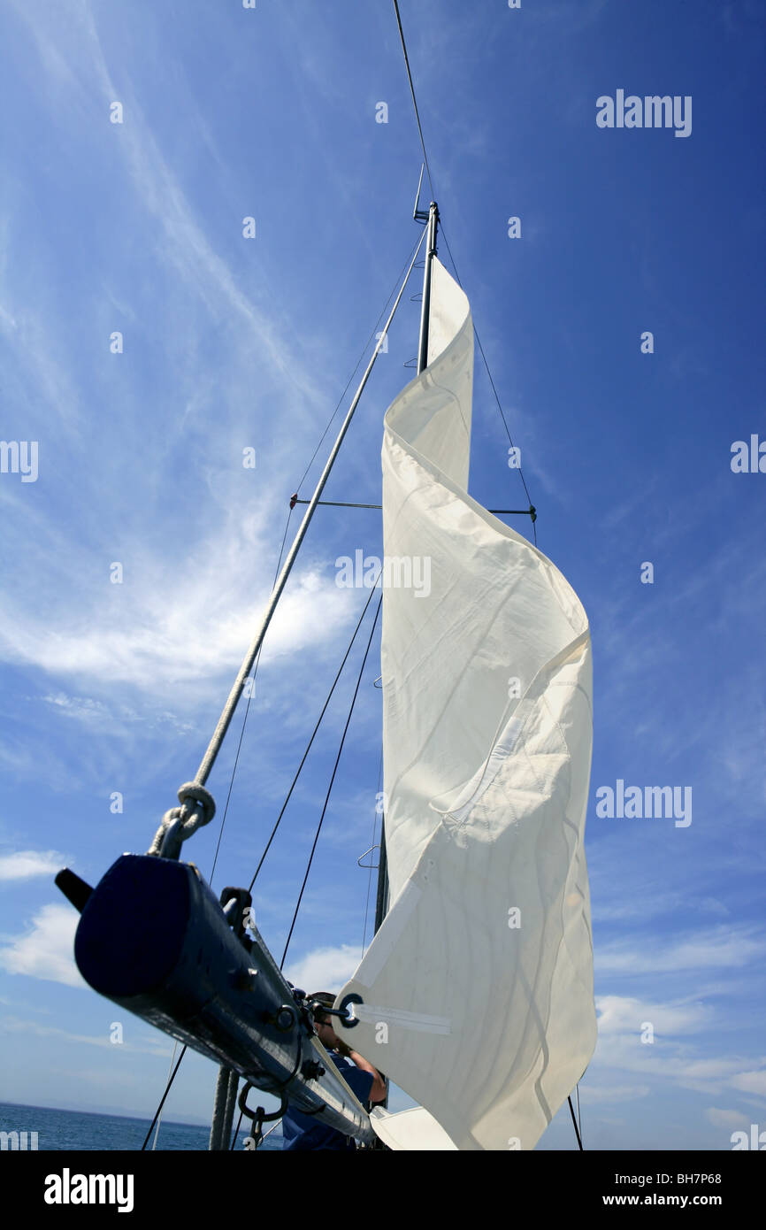 Sailor in sailboat rigging the sails over sunny summer blue sky Stock ...