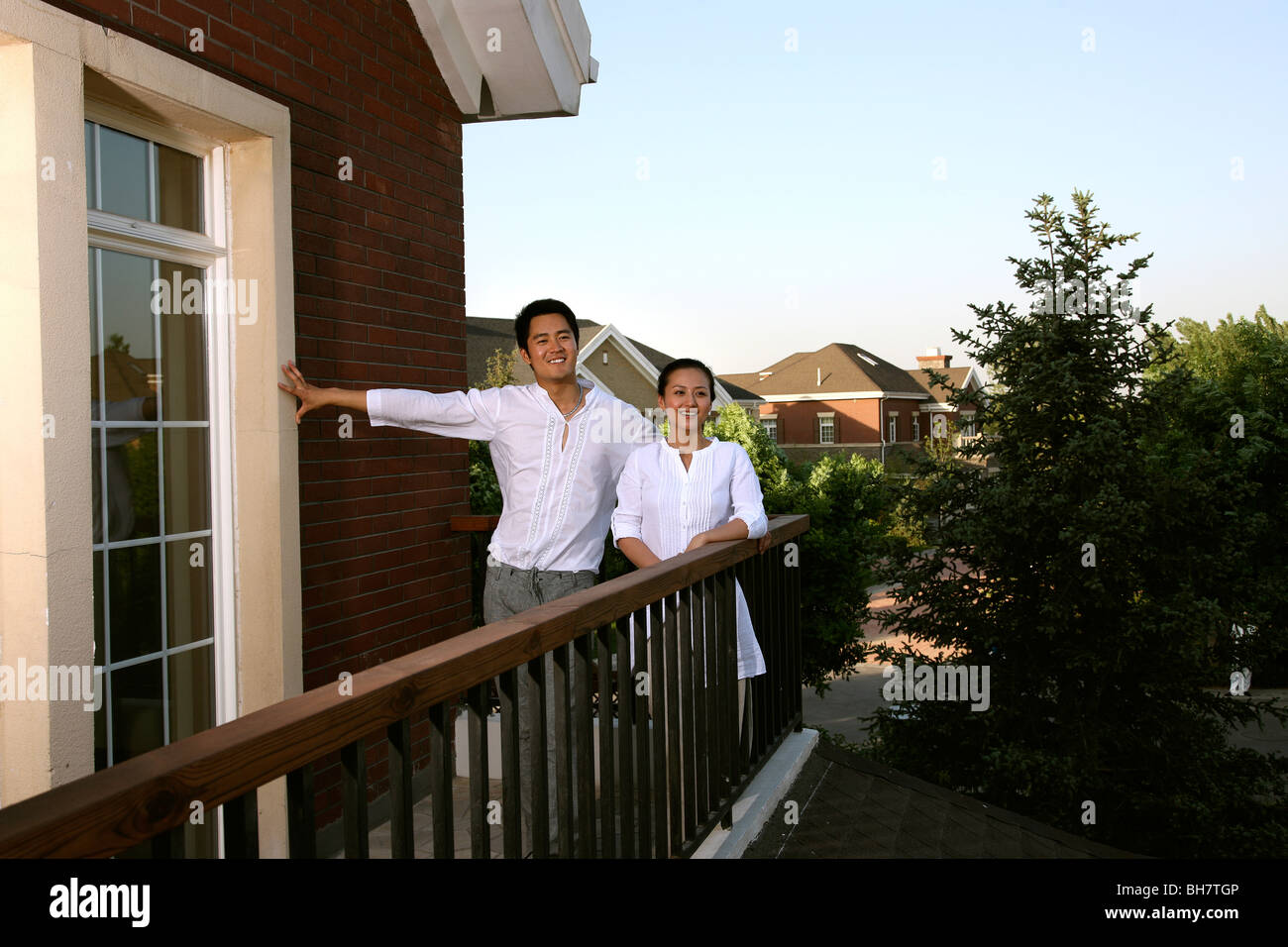 Chinese young couple standing on balcony Stock Photo - Alamy