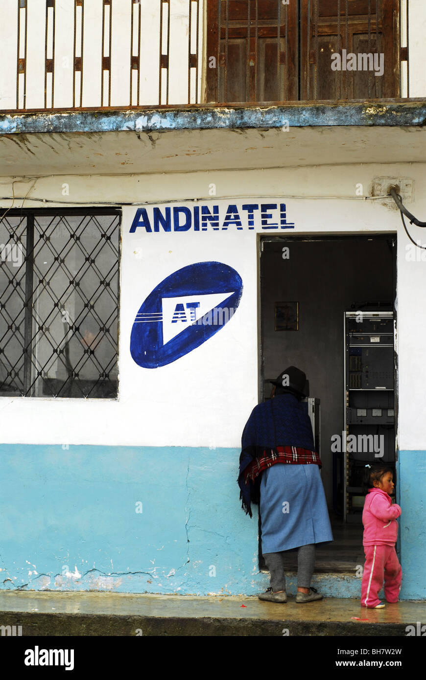 Ecuador, Latacunga, woman peeking into a house, with the sign andinatel ...