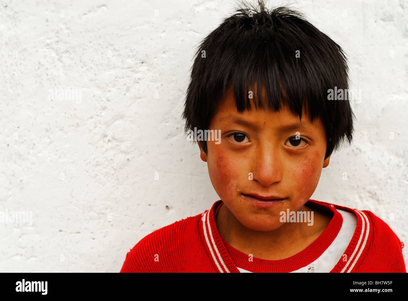 Ecuador, Latacunga, close-up portrait of a young boy wearing red and ...