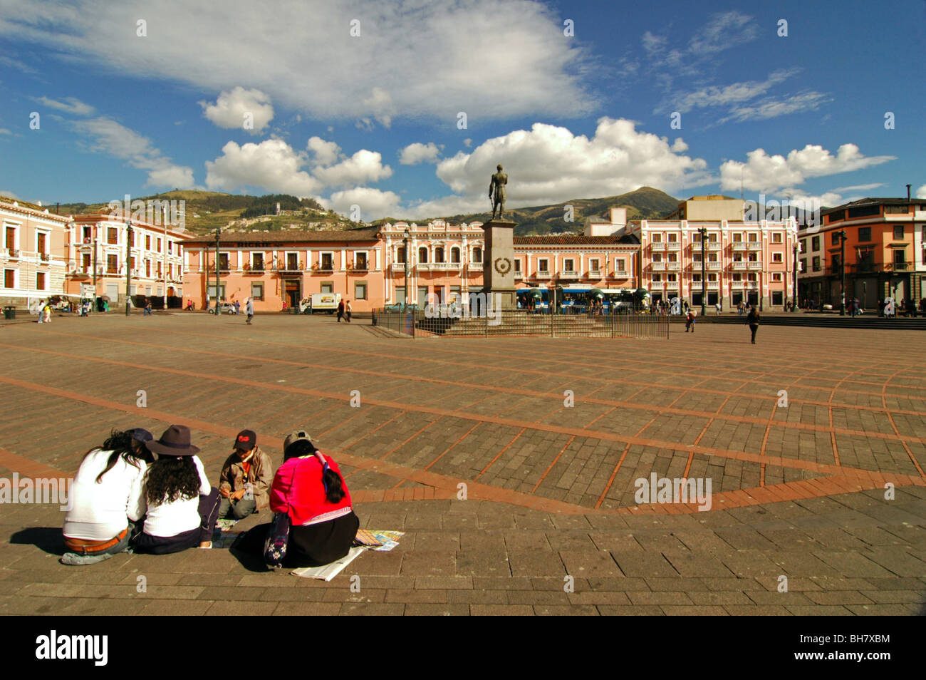 Ecuador, Quito, Ecuadorian people sitting on the ground on Quito city ...