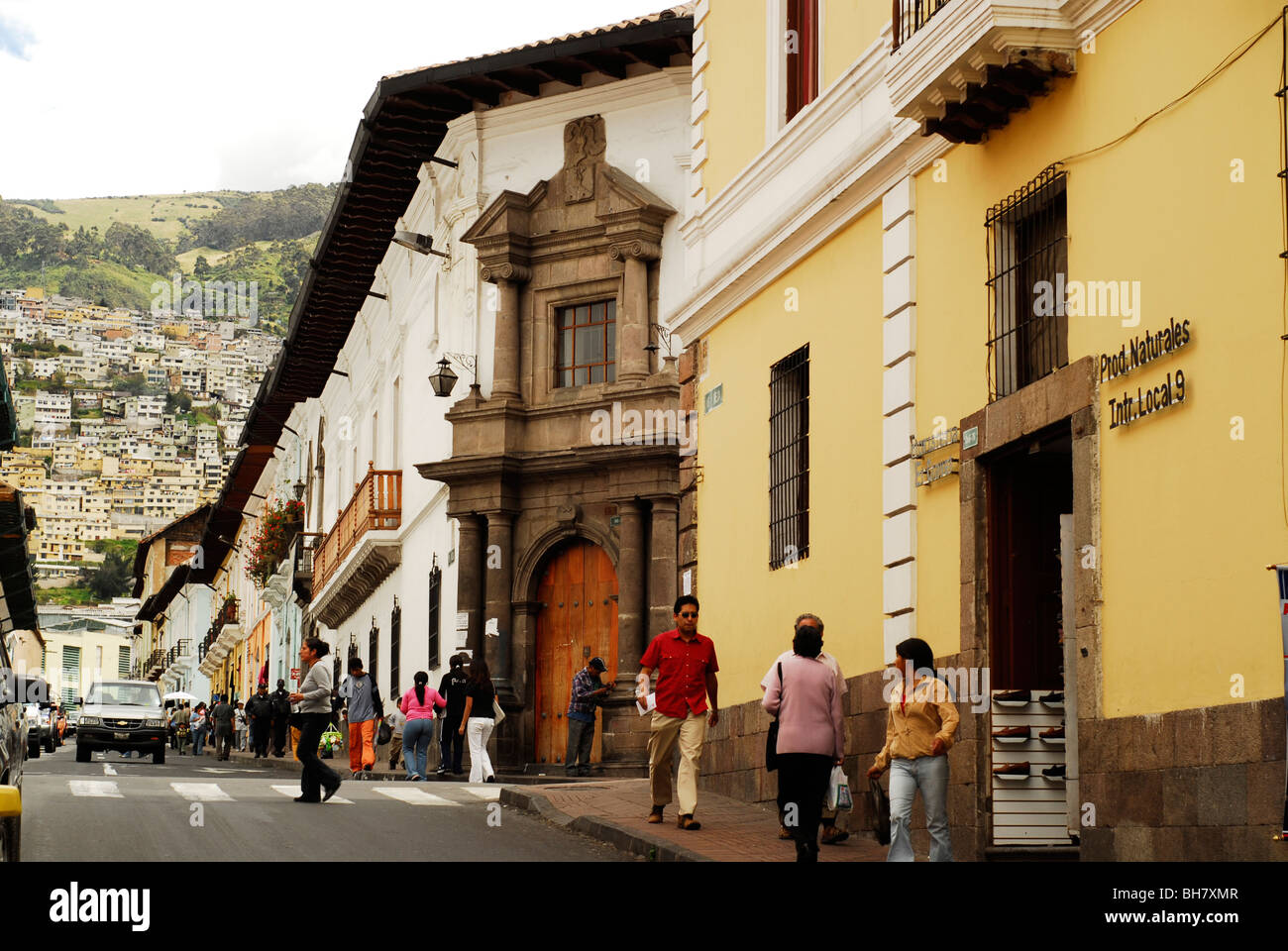 Ecuador, Quito, buildings in a row by a road and people walking on the ...