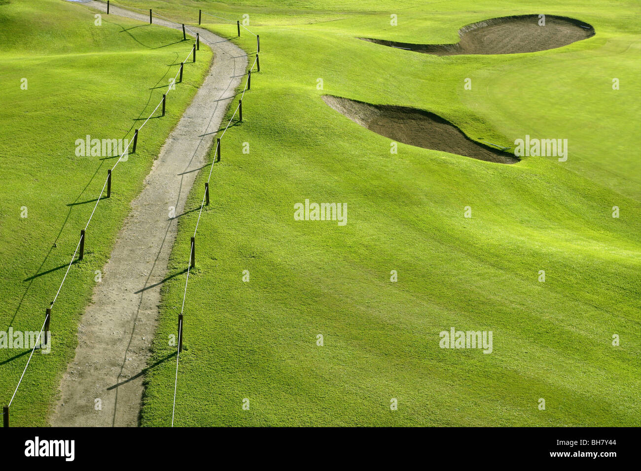 Golf course green grass hill field with holes and track way Stock Photo ...