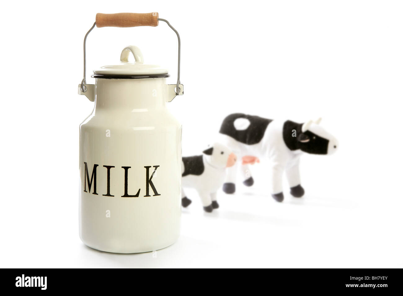 Milk urn white pot with blurred toy cows isolated on white Stock Photo ...