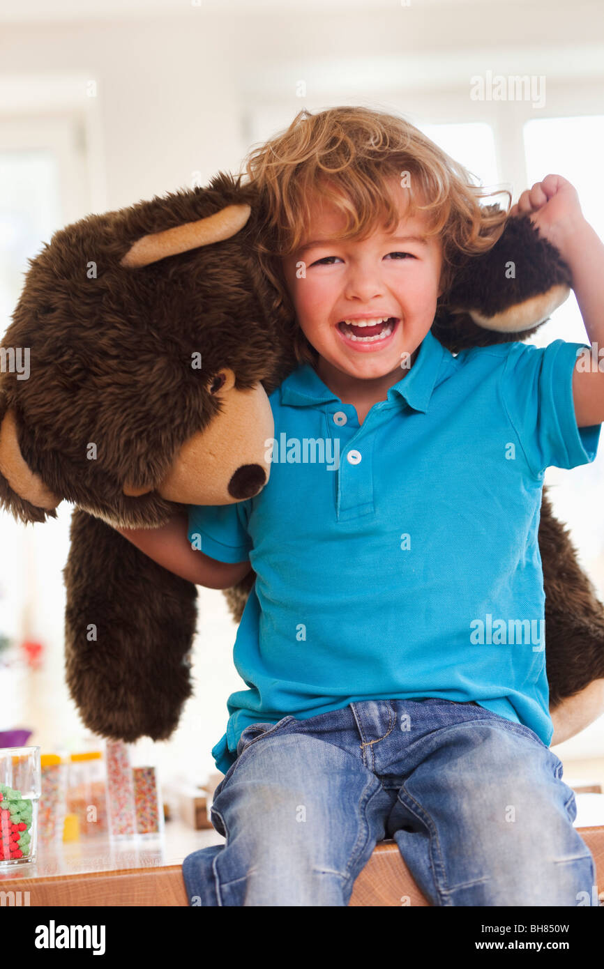 Young boy playing with teddy bear Stock Photo - Alamy