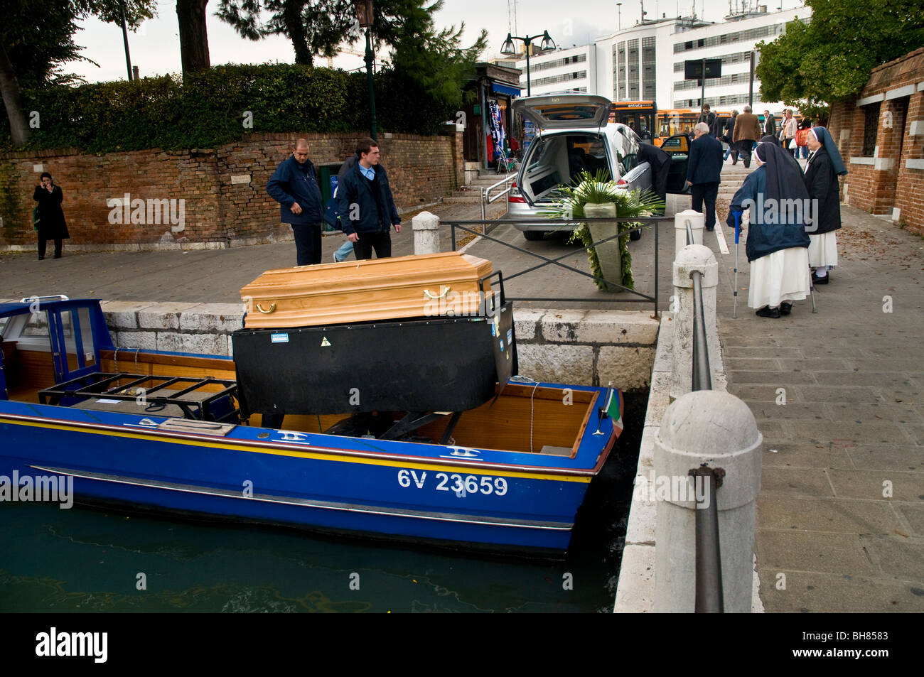 Venice special boat for transporting coffins arrive at the quayside and ...