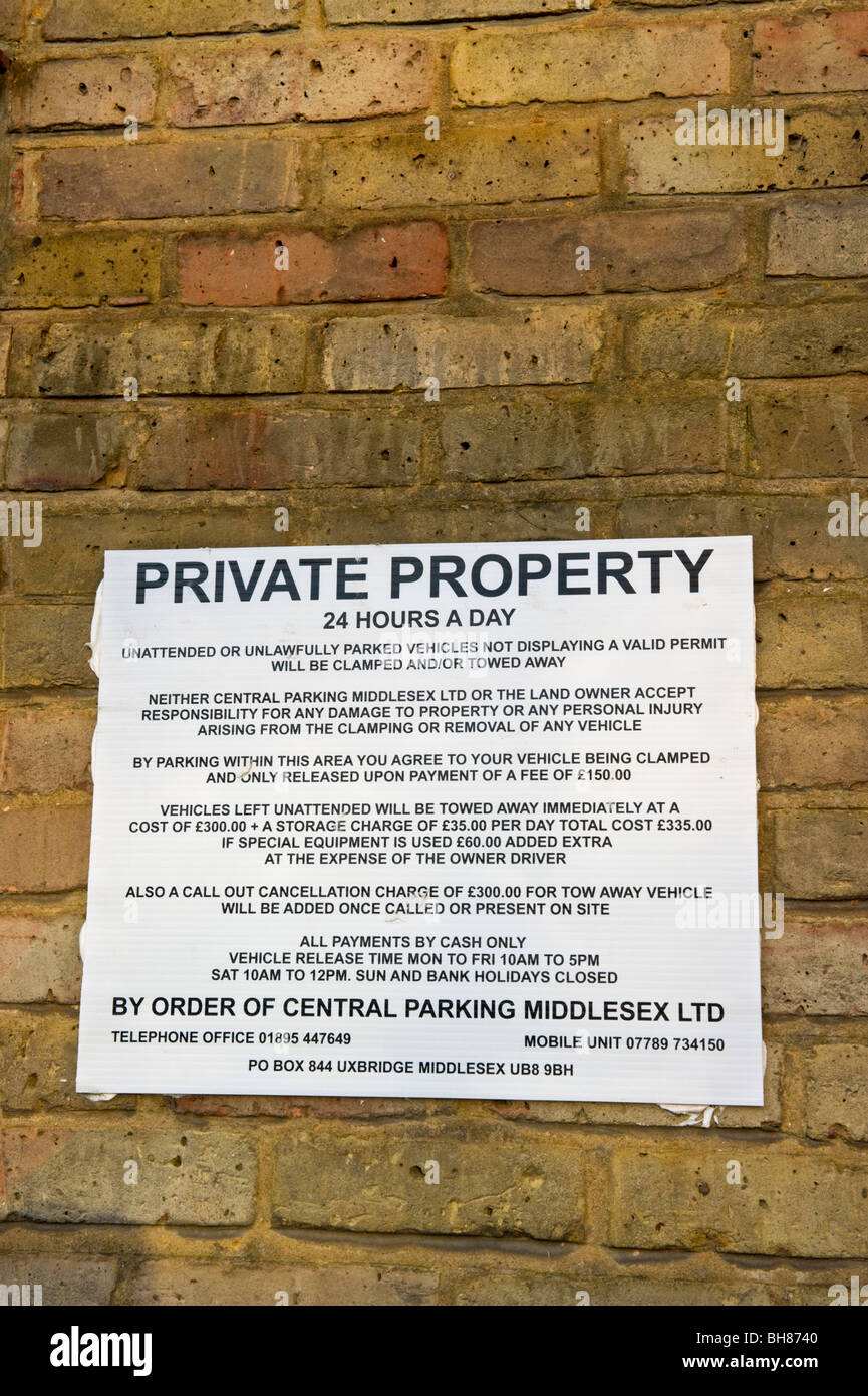 Car clamping notice on a brick wall on private property Stock Photo - Alamy