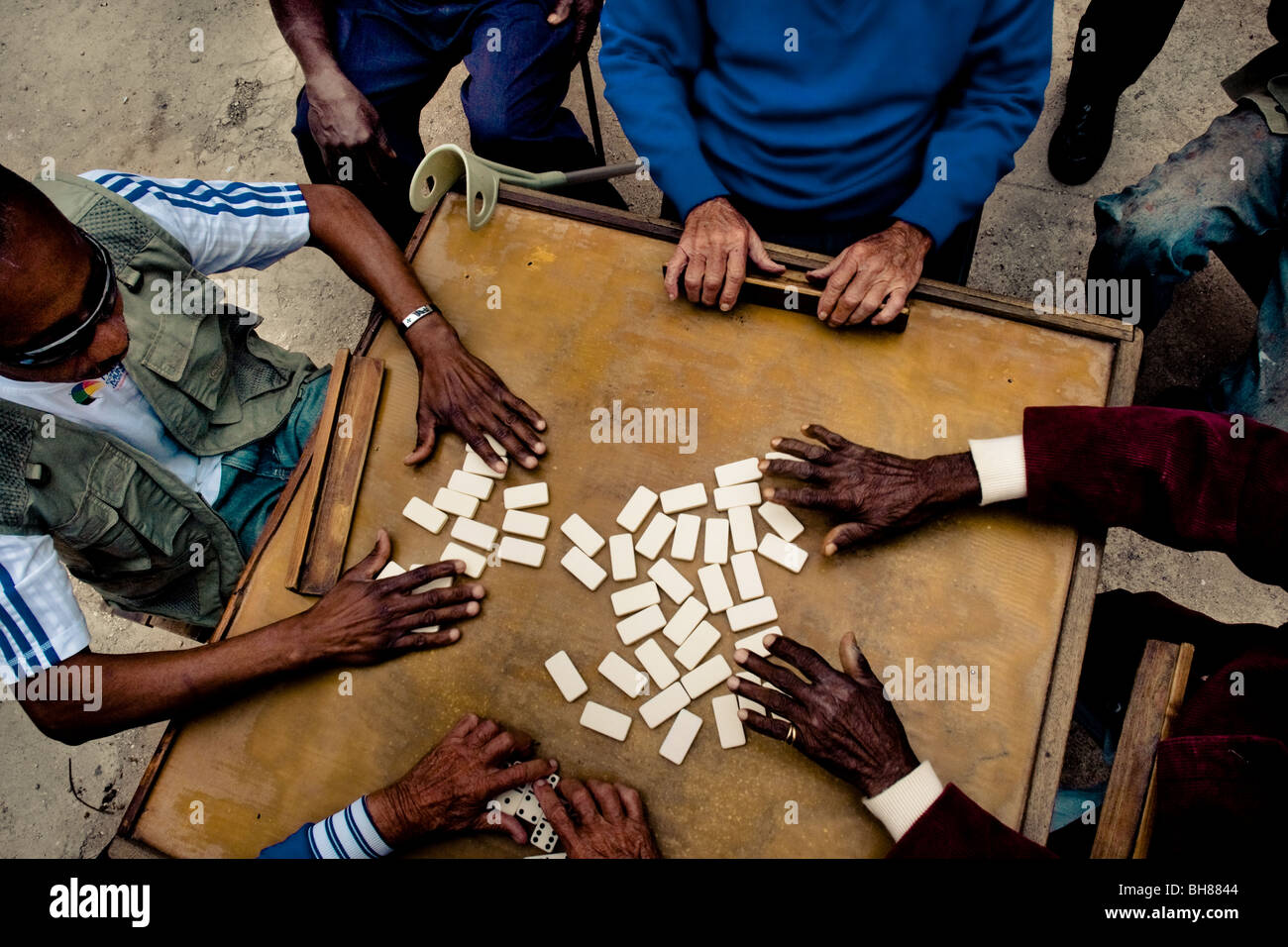 Cuban men shuffle the dominoes tiles while playing the game on the ...