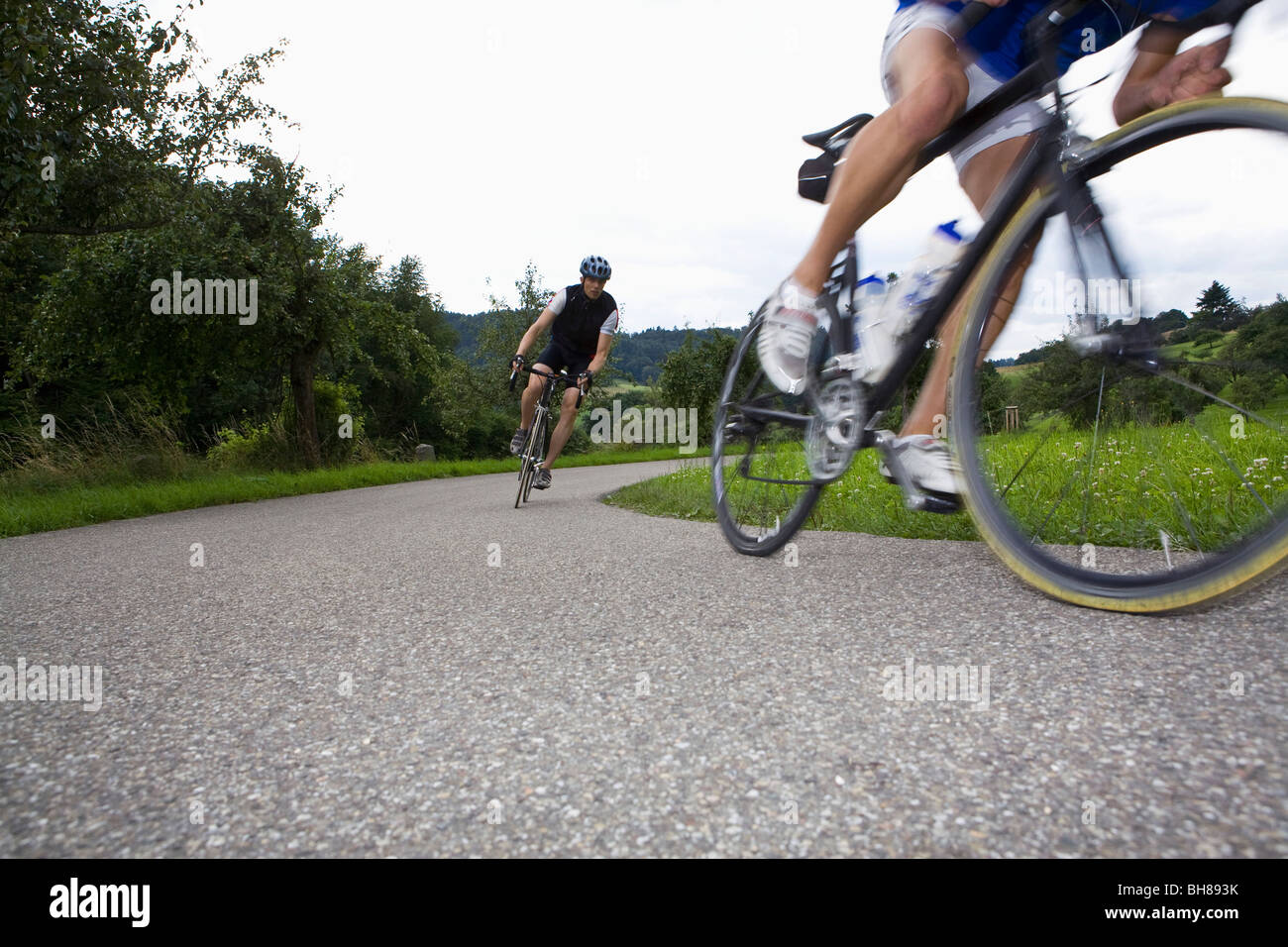Two men cycling on a road Stock Photo - Alamy