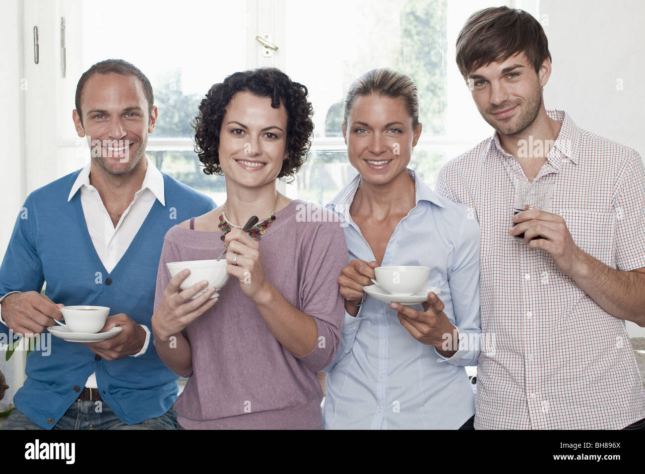 Friends standing in a row and smiling Stock Photo - Alamy