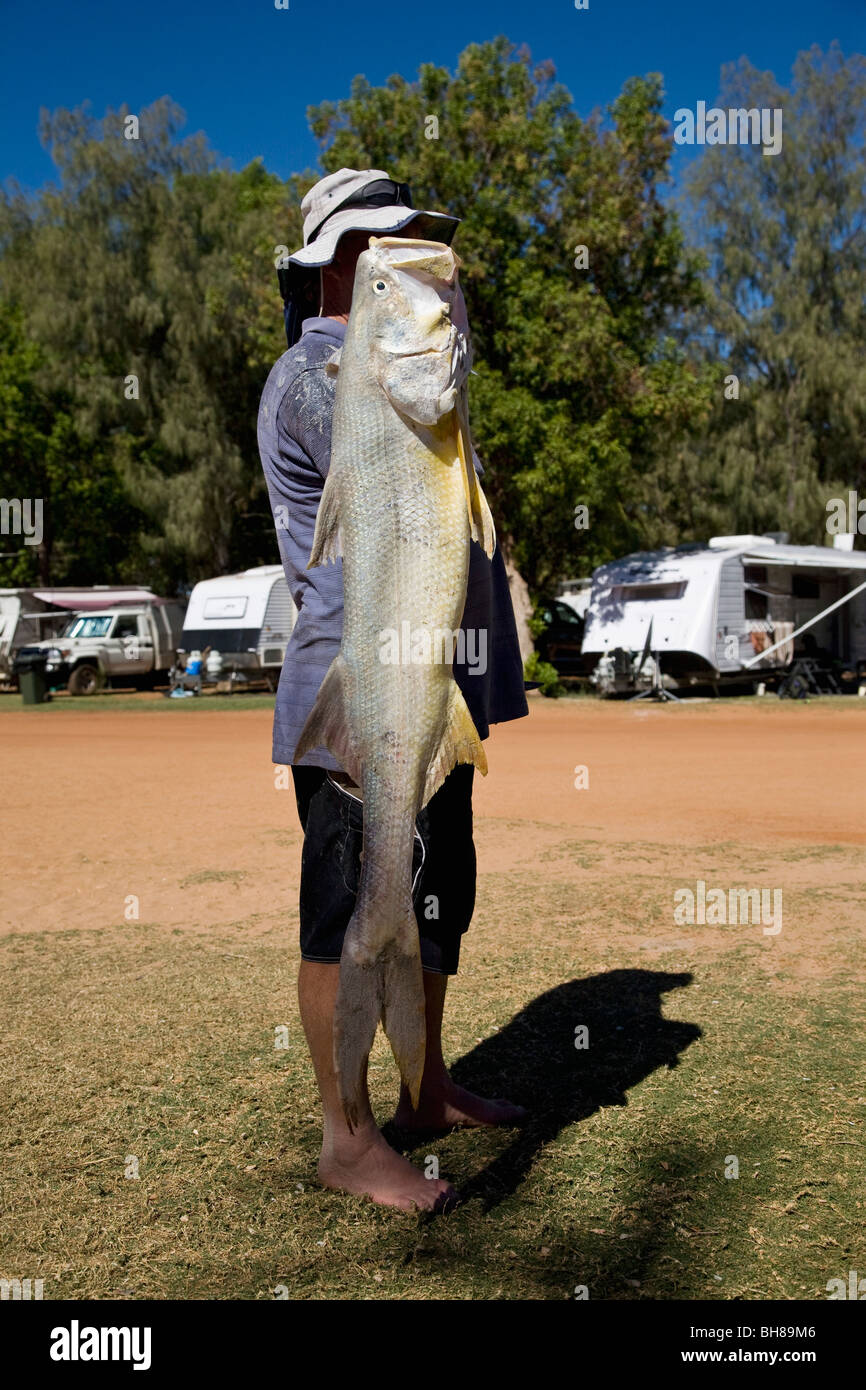 Side view of a man holding a large fish Stock Photo - Alamy