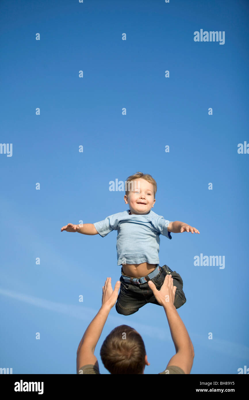 A boy being thrown into the air by a man Stock Photo - Alamy