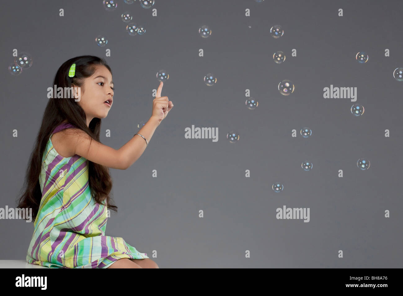 Girl trying to touch a bubble Stock Photo - Alamy