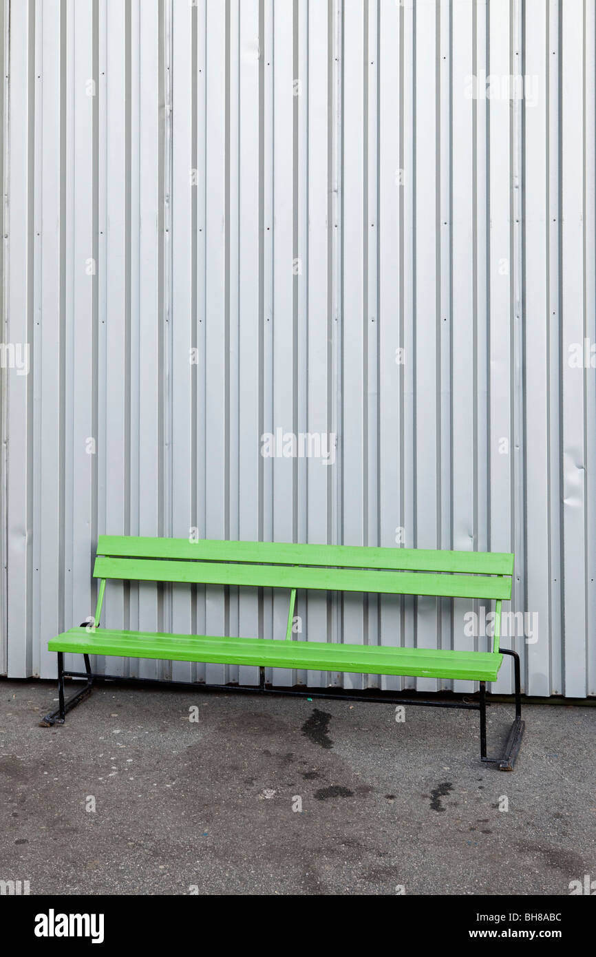 A green bench in front of a steel building Stock Photo - Alamy