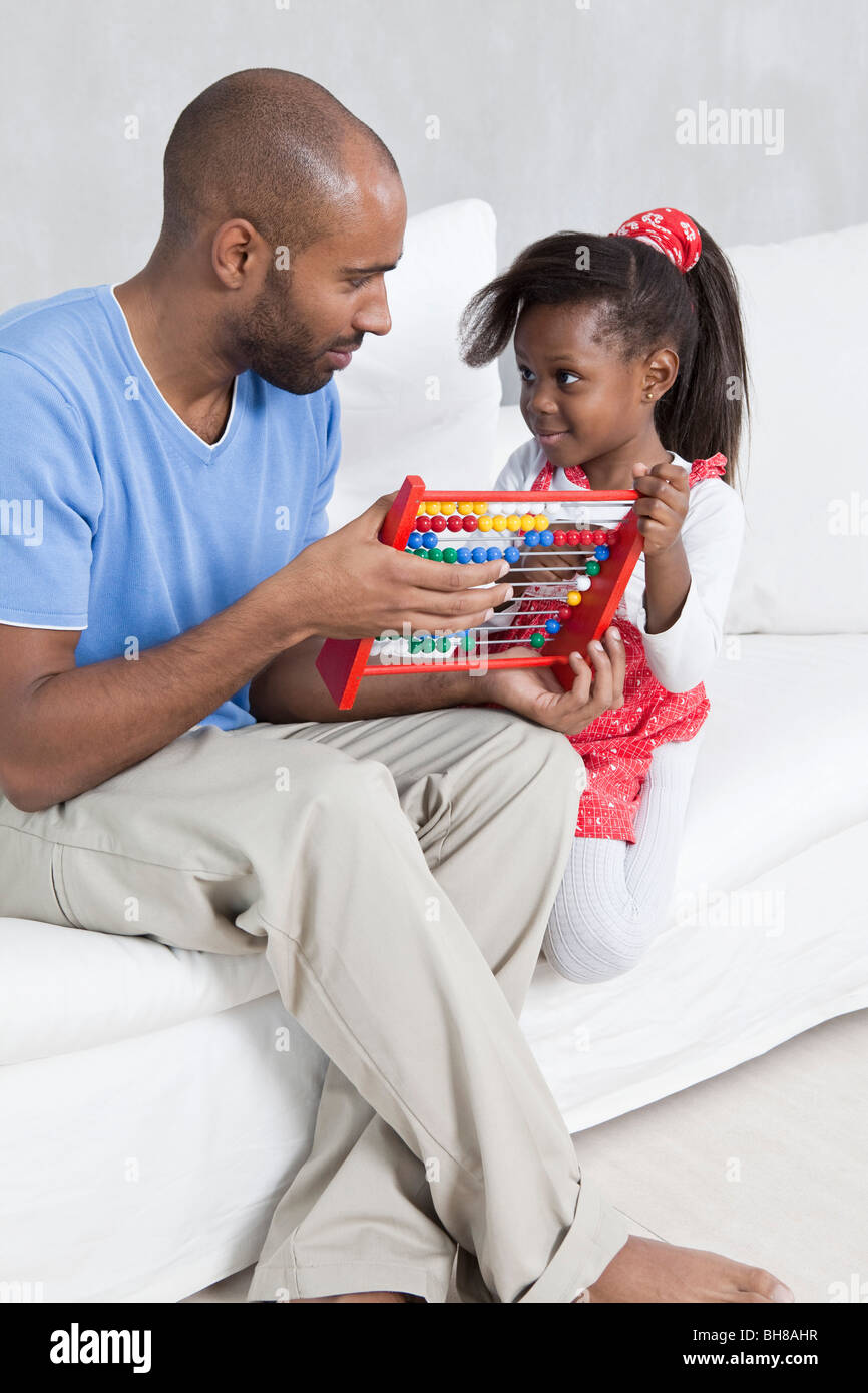 A father showing his young daughter how to use an abacus Stock Photo ...