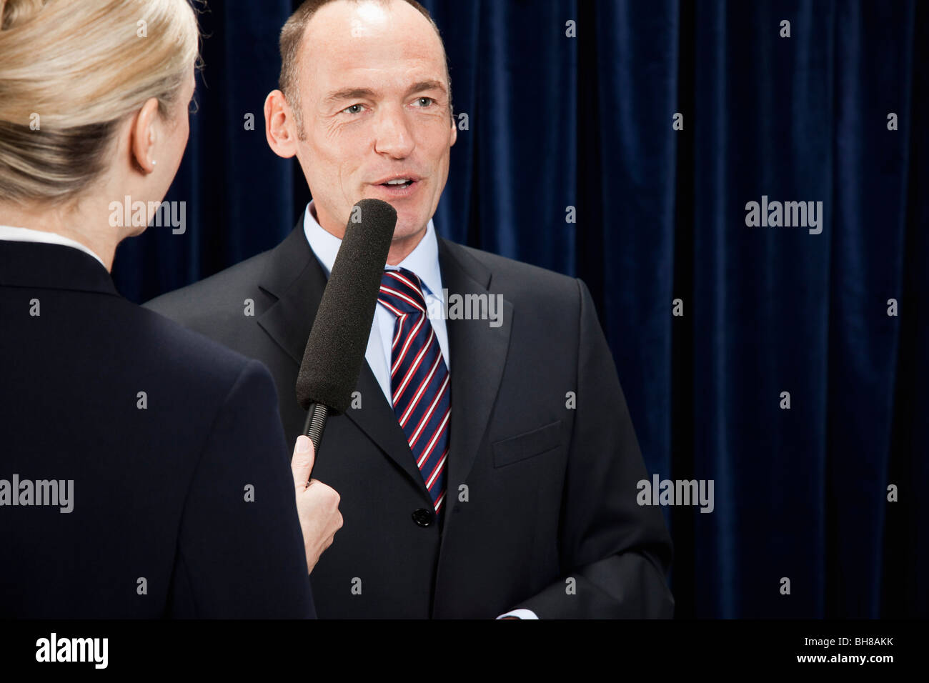 A man in a suit being interviewed Stock Photo - Alamy