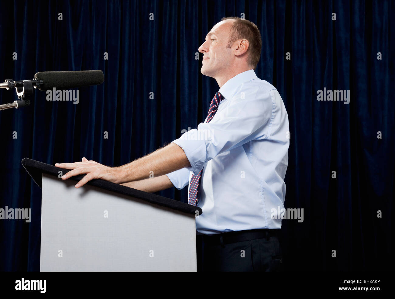 Side view of a man standing at a lectern Stock Photo - Alamy