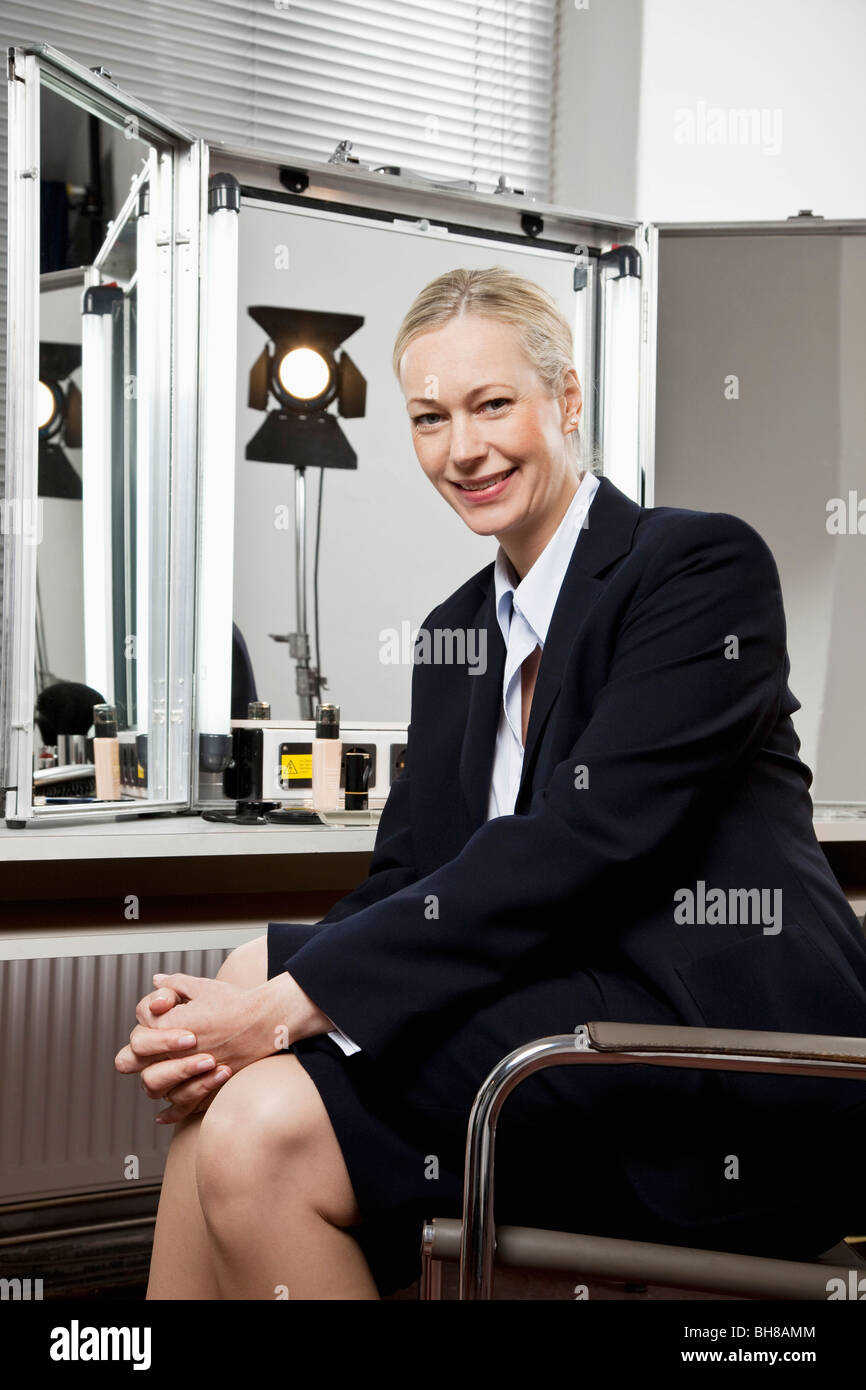 A woman in a suit sitting backstage Stock Photo - Alamy
