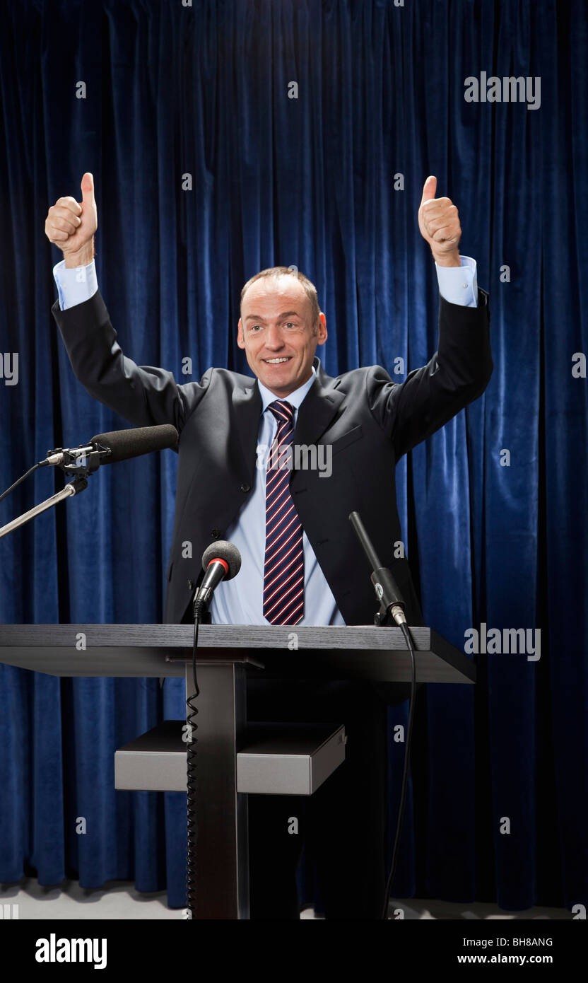 A man in a suit gesturing at a lectern Stock Photo - Alamy