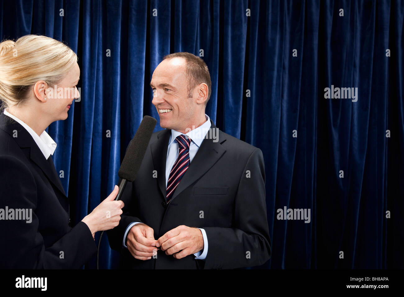A man in a suit being interviewed by a woman Stock Photo - Alamy