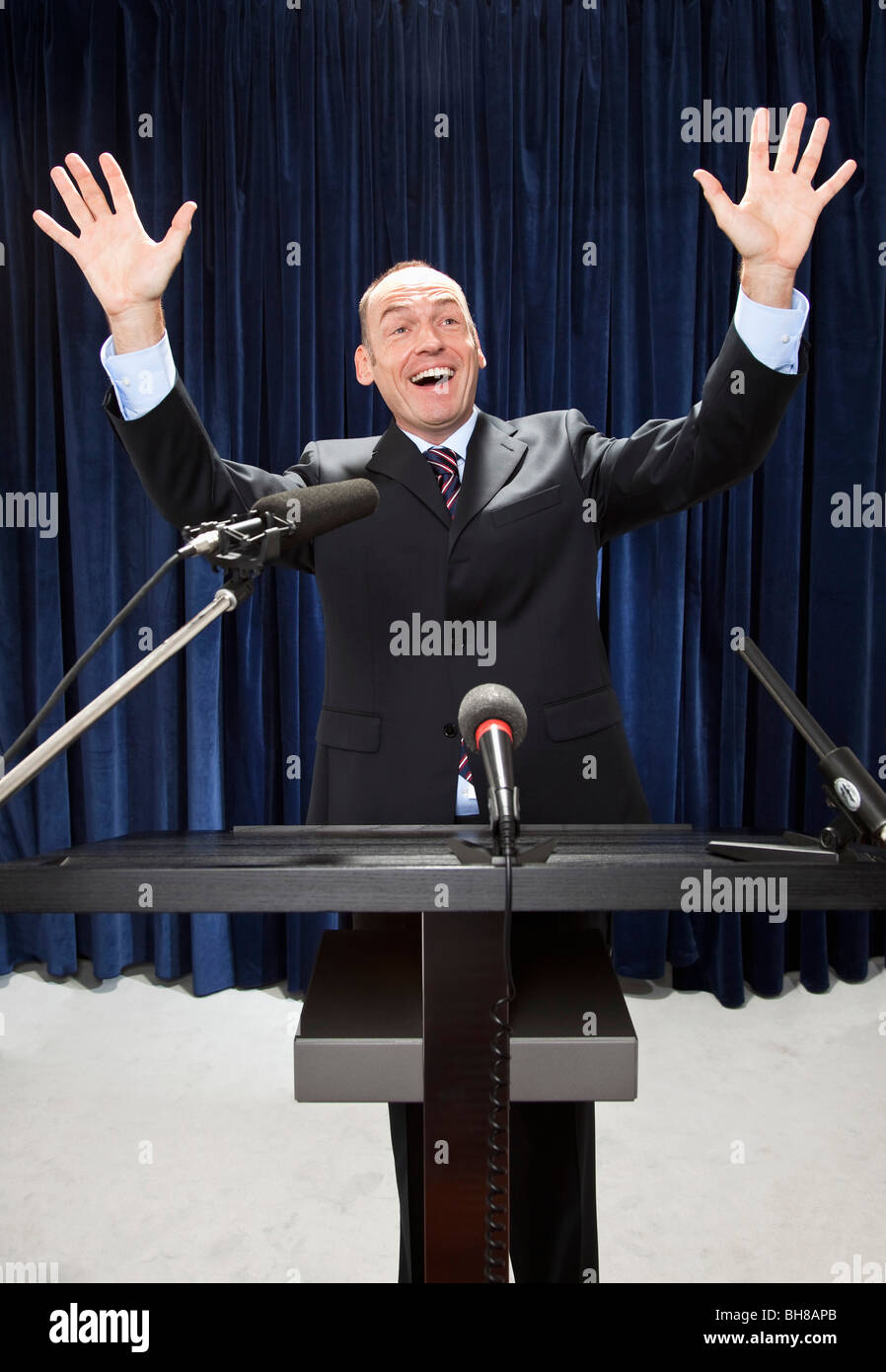 A man in a suit gesturing at a lectern Stock Photo - Alamy