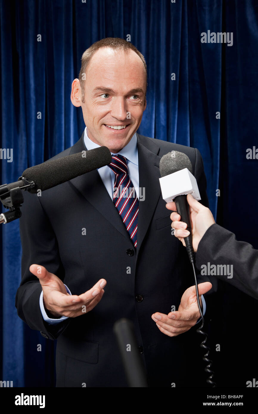 A man in a suit being interviewed by the media Stock Photo - Alamy