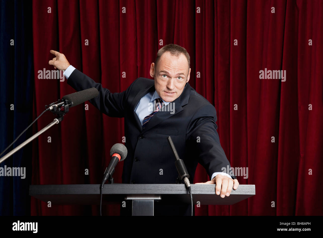 A man in a suit gesturing at a lectern Stock Photo - Alamy