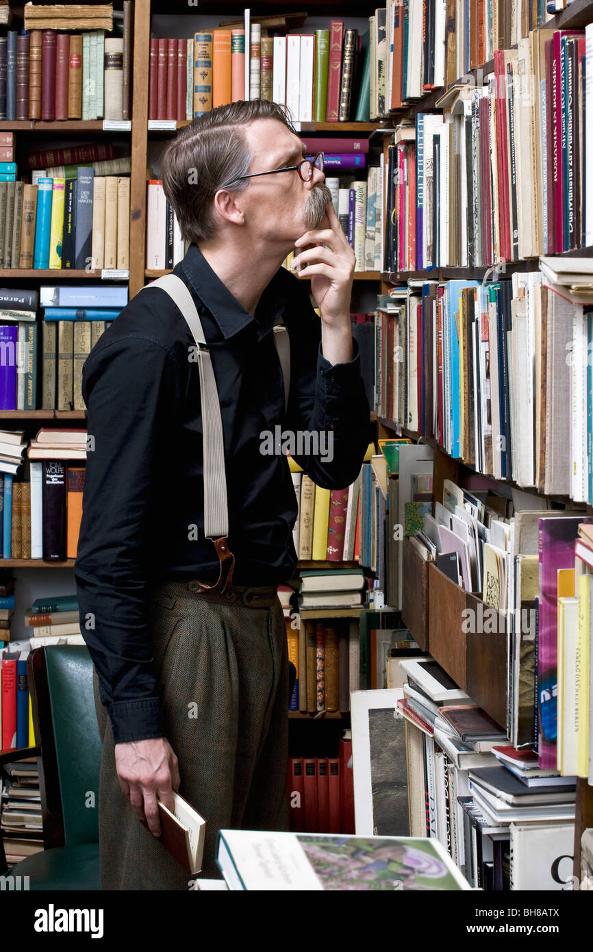 A man scrutinizing books in a bookstore Stock Photo - Alamy