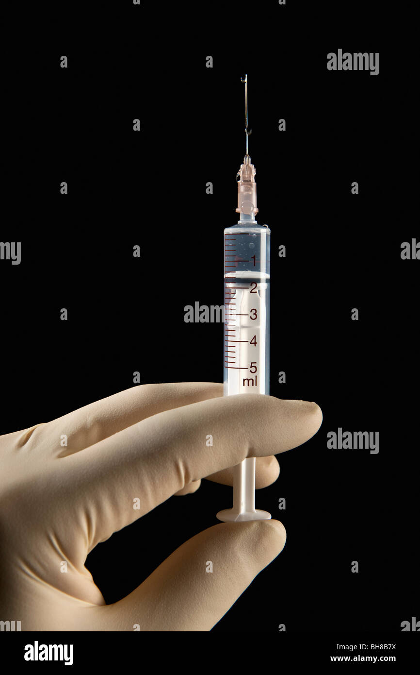 Detail of a hand holding a syringe Stock Photo - Alamy