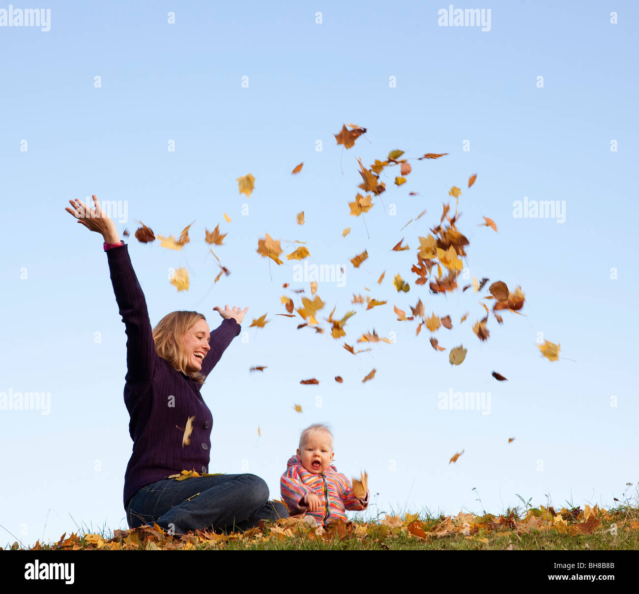 mother and baby throwing autumn leaves Stock Photo - Alamy