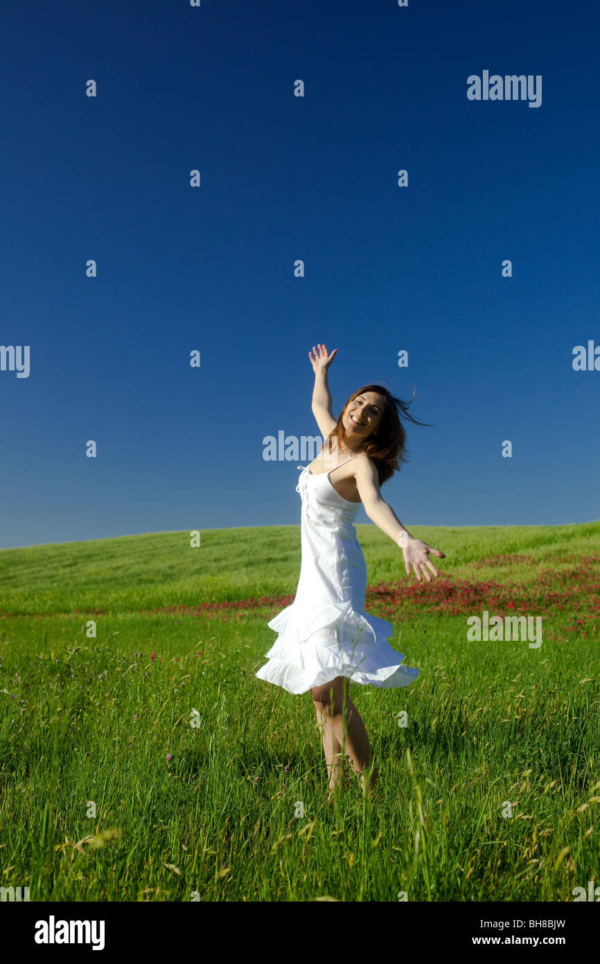 Beautiful happy young woman dancing on the field Stock Photo - Alamy