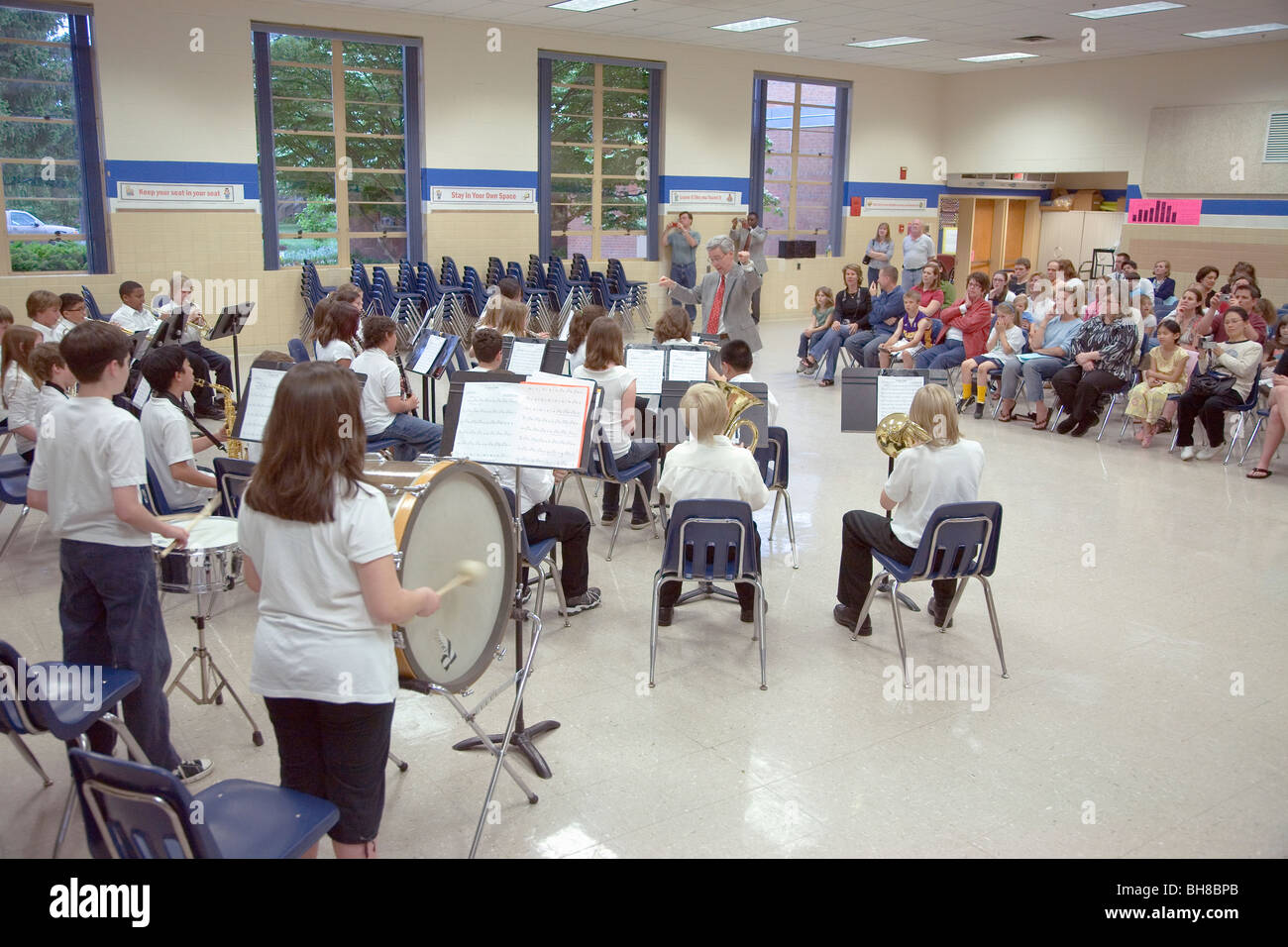 Grade school band conductor leads school 5th grade band recital at ...