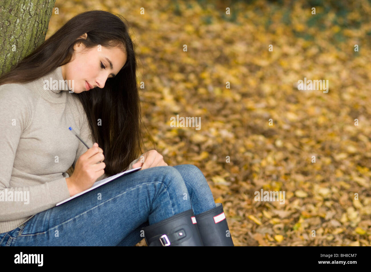 girl writing against a tree Stock Photo - Alamy