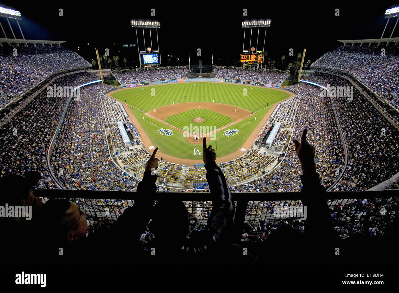 Silhouette of Dodger fans cheer and point from grandstands overlooking ...