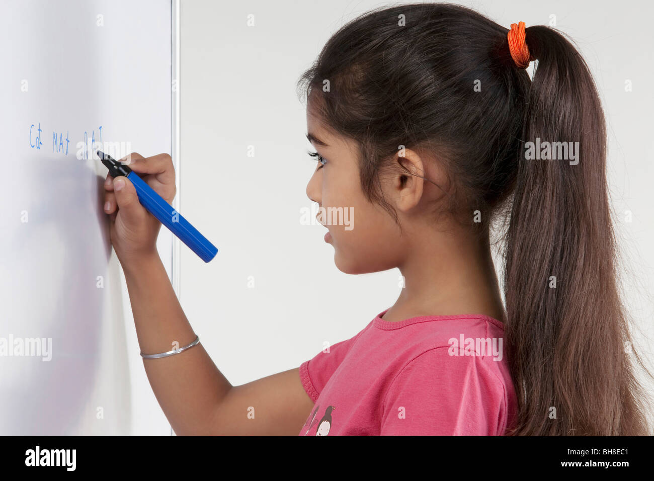 Girl writing on a board Stock Photo - Alamy