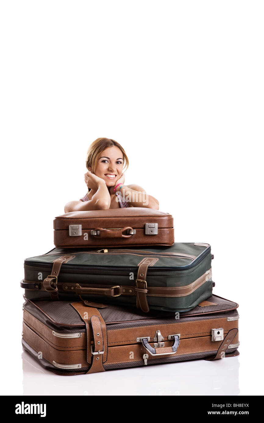 Beautiful and happy young woman behind the baggage, isolated on white ...