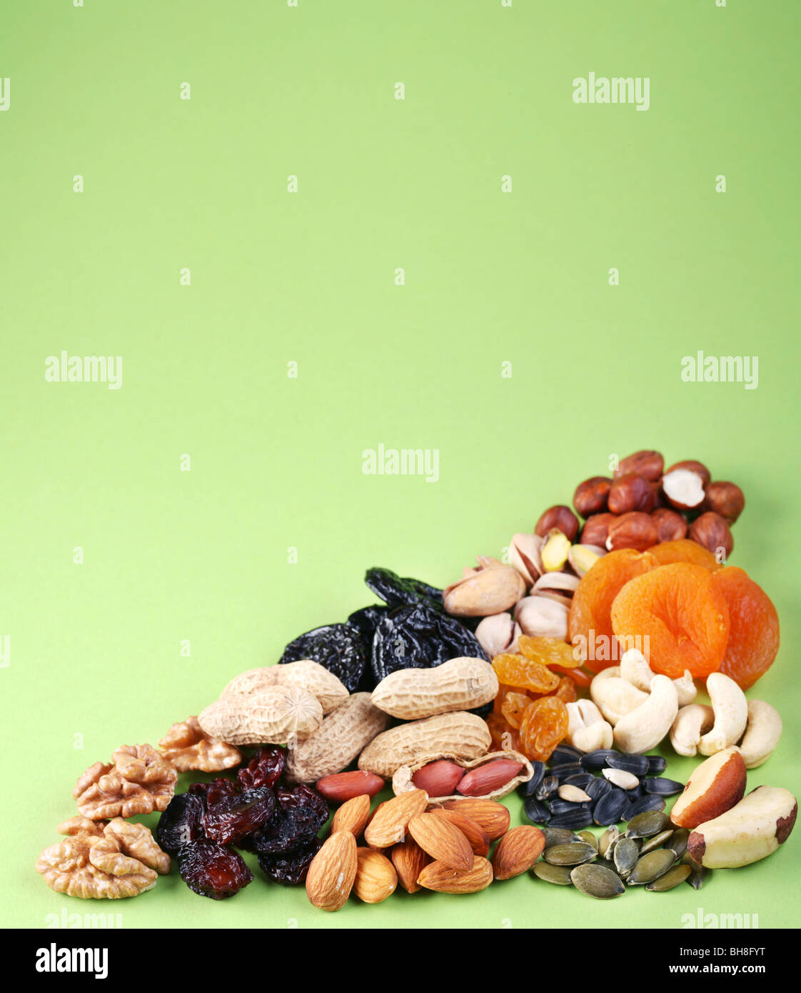 Groups of various kinds of dried fruits on green background Stock Photo ...