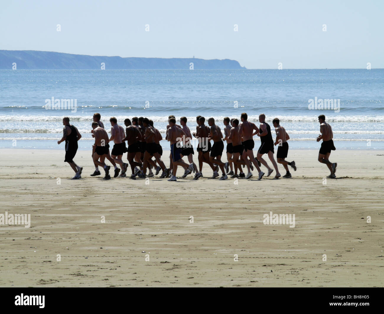 armed service personnel running in a squad along a beach Stock Photo ...
