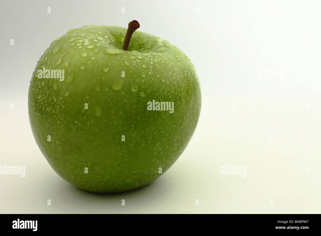 Apple single green against a white background Stock Photo - Alamy