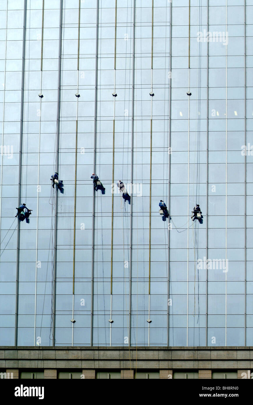 Workers wiping windows of a building Stock Photo - Alamy