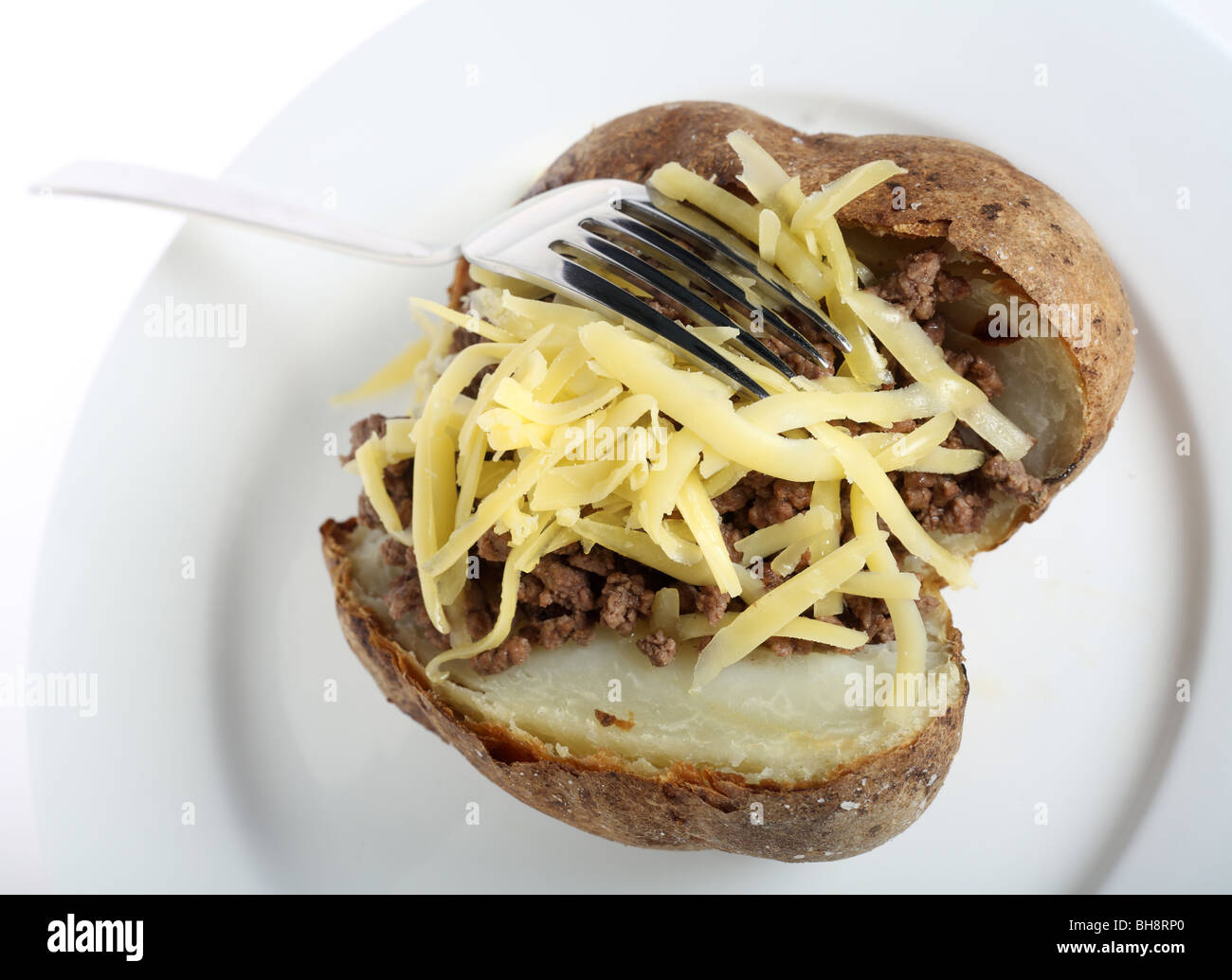 A jacket or baked potato topped with minced beef and cheese, with a ...