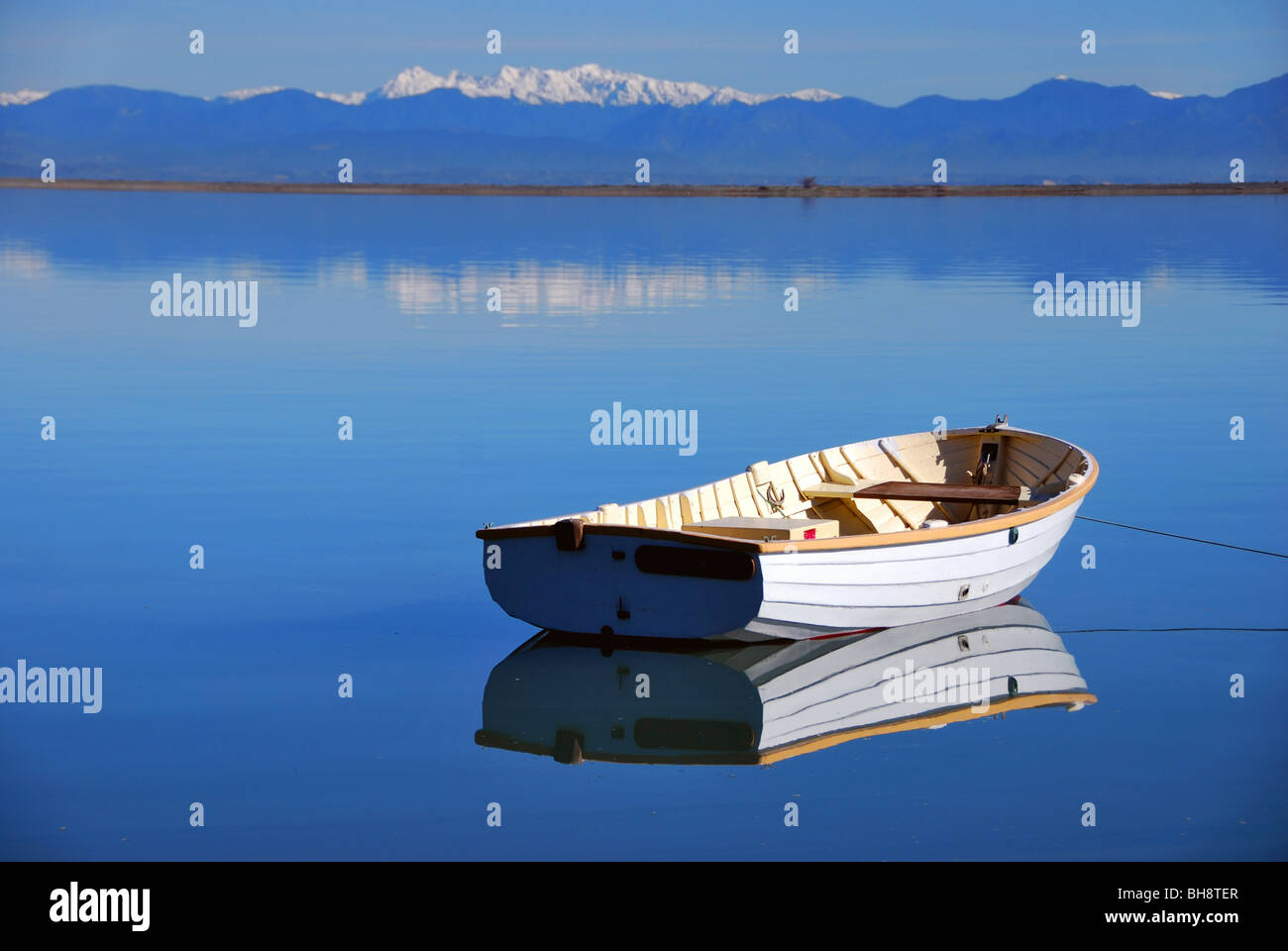 White carvel built rowing boat at mooring on peaceful, calm Tasman Bay ...